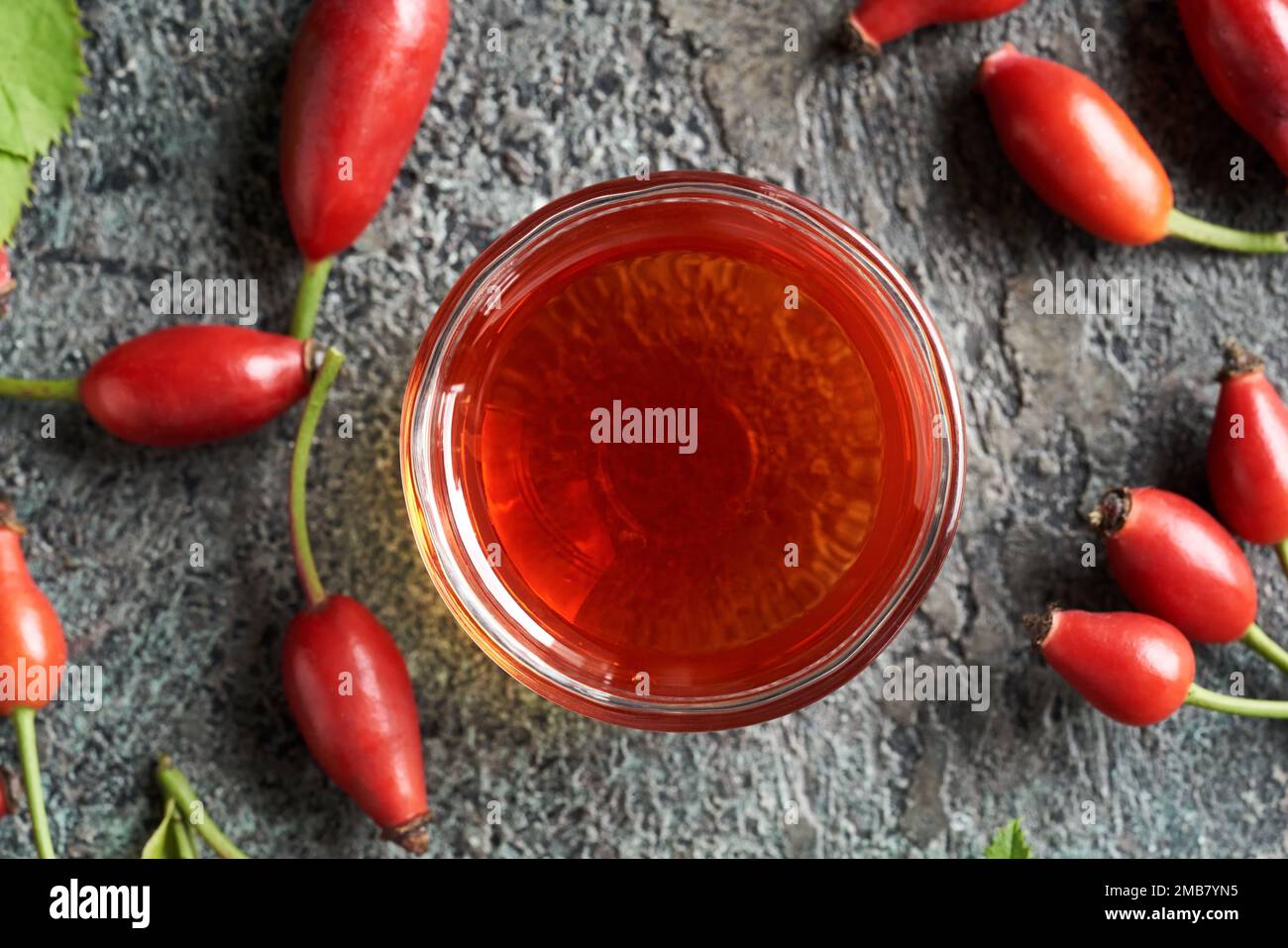 Red rose hip seed oil with fresh berries, top view Stock Photo - Alamy