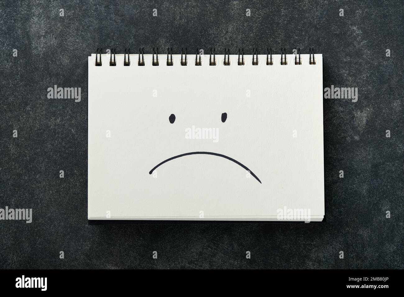 Blue crumpled sticky notes blank with drawing sad face on black ...