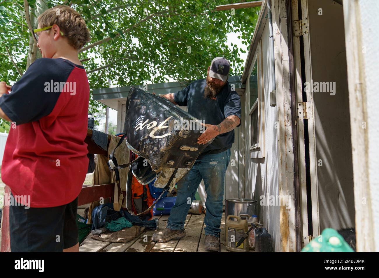 Matt Holmes, right, drains a suitcase while packing up belongings with ...