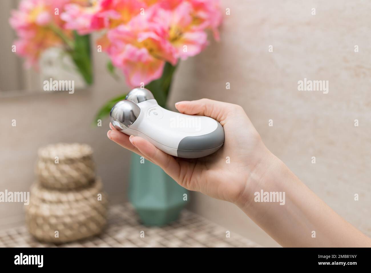 female hand holding microcurrent facial toning device. skin care Stock ...