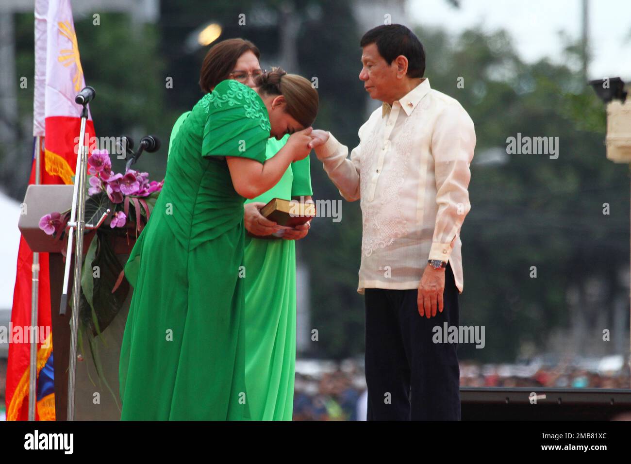 Philippine Vice President-elect Sara Duterte, left, places the hands of ...