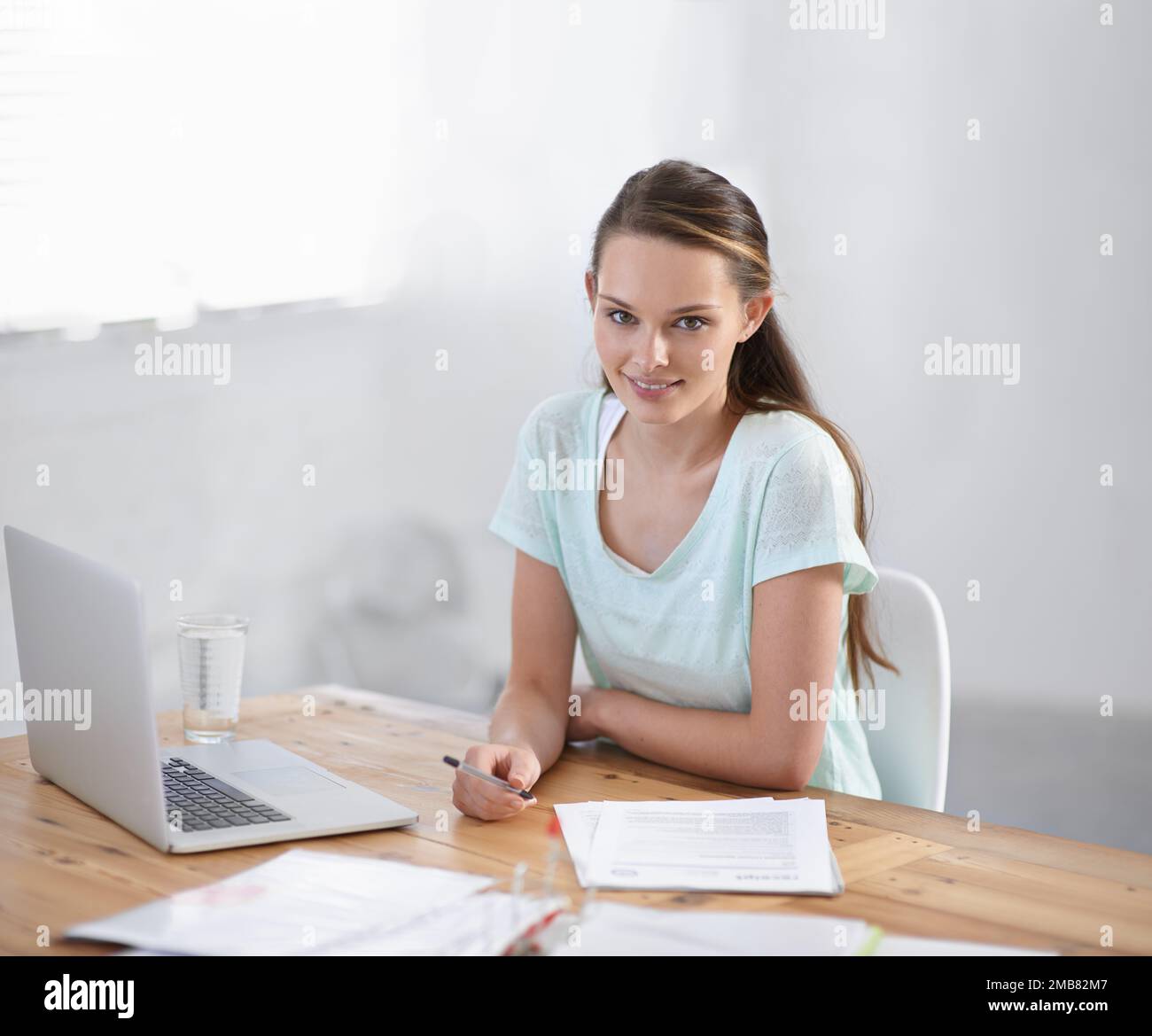 Admin queen. A lovely young businesswoman examining paperwork at her ...