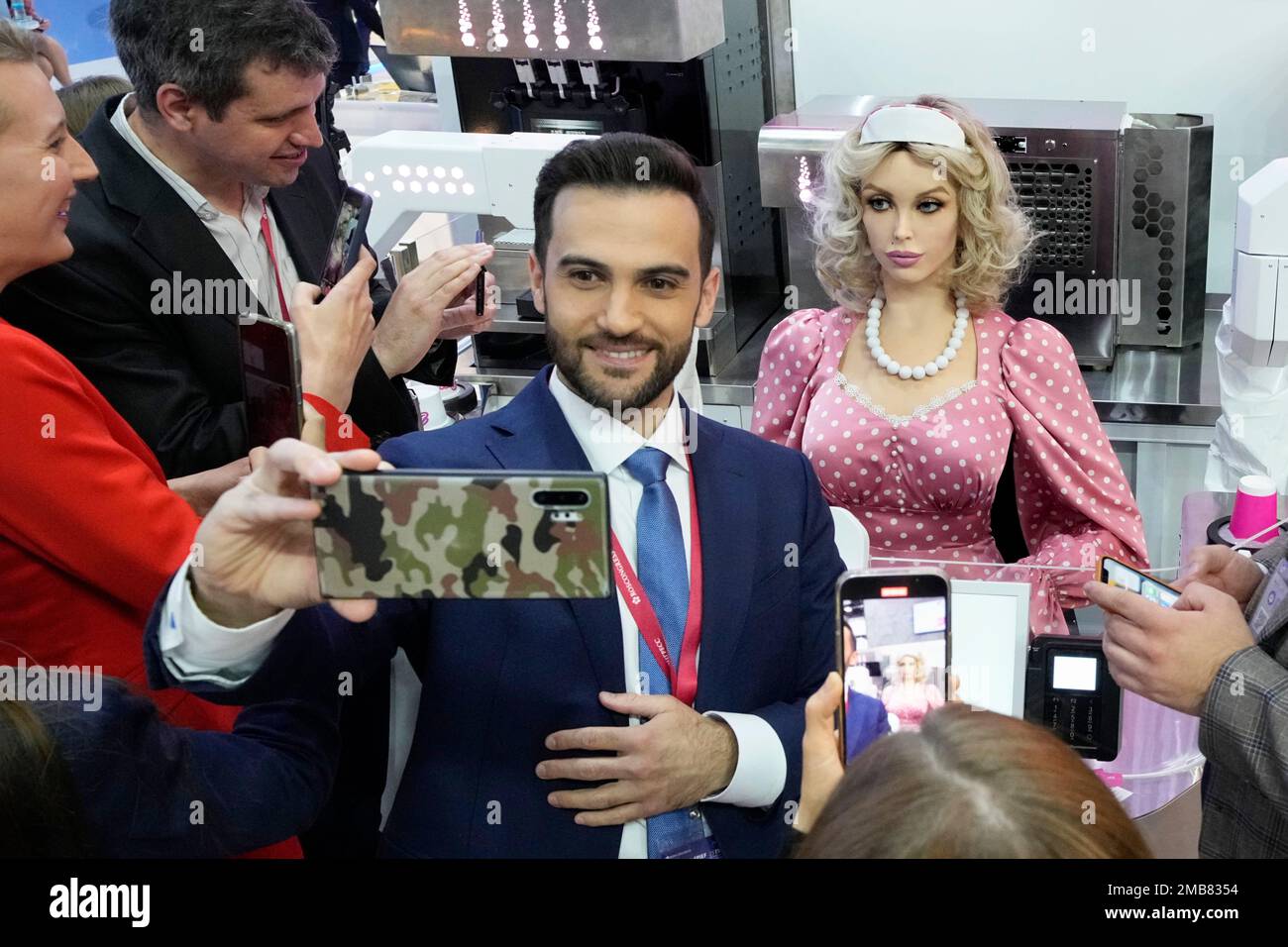 Participants take selfies as Dunyasha, anthropomorphic female cashier ...