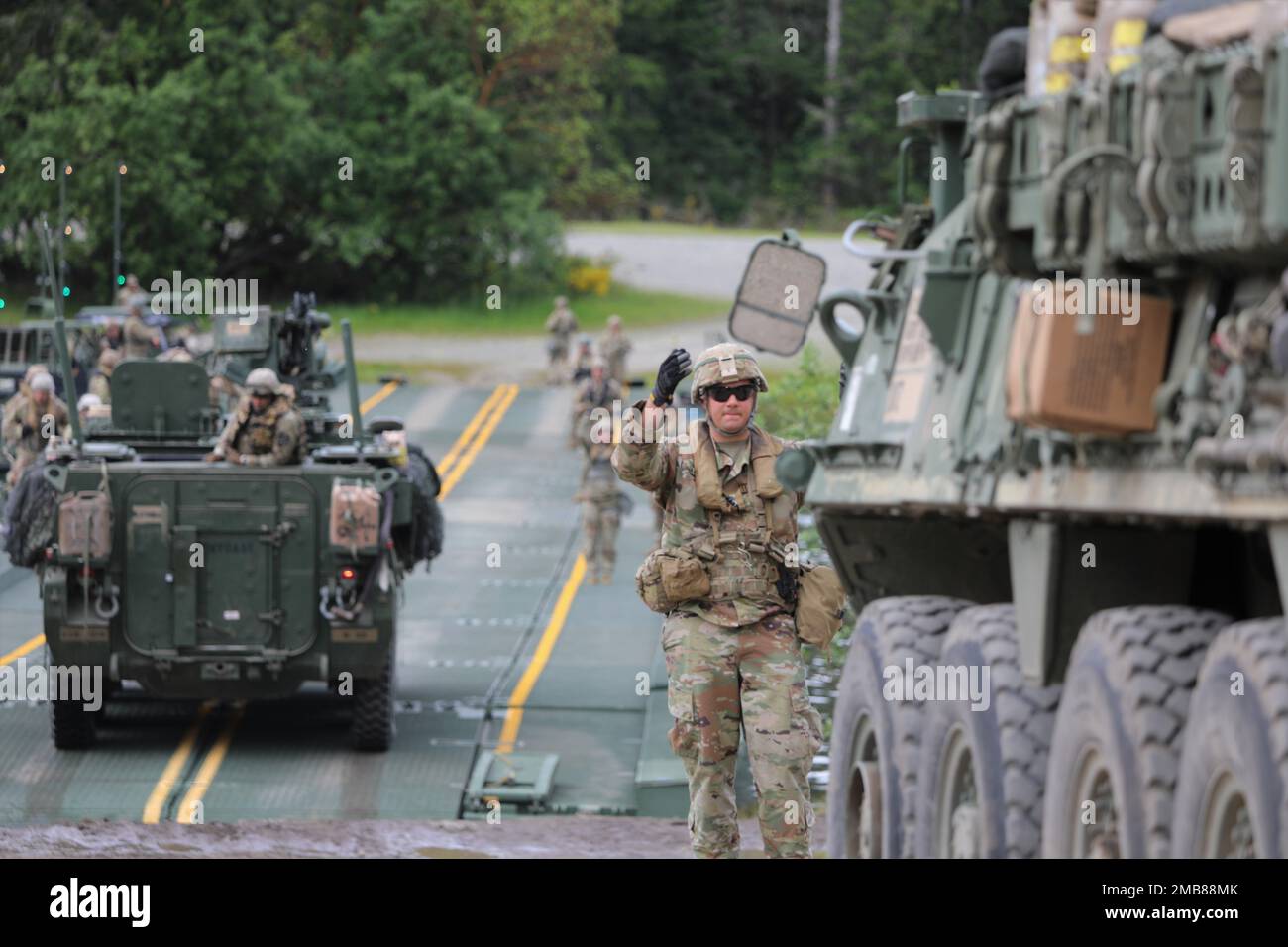 Strykers use a ground guide from the nearside to board the hasty bridge ...