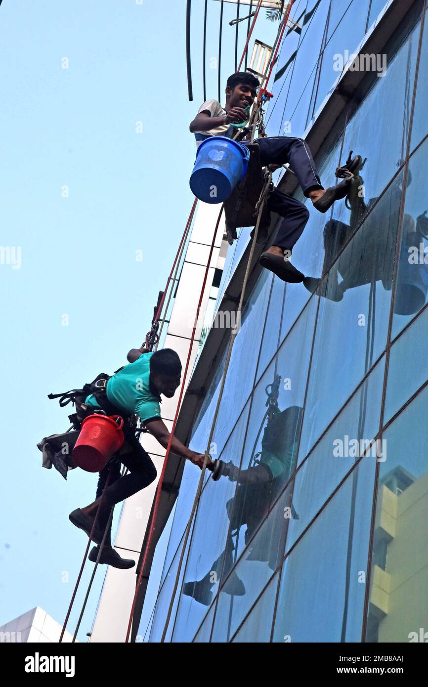 Workers glass cline a high-rise building on a construction site area in ...