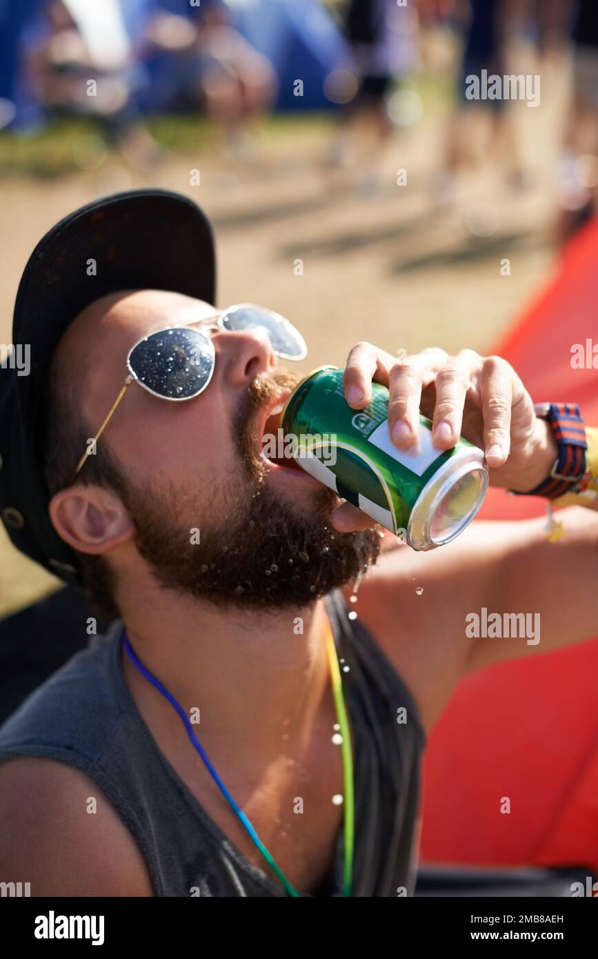 Enjoying a frosty one on a hot day. a guy drinking beer at an outdoor ...