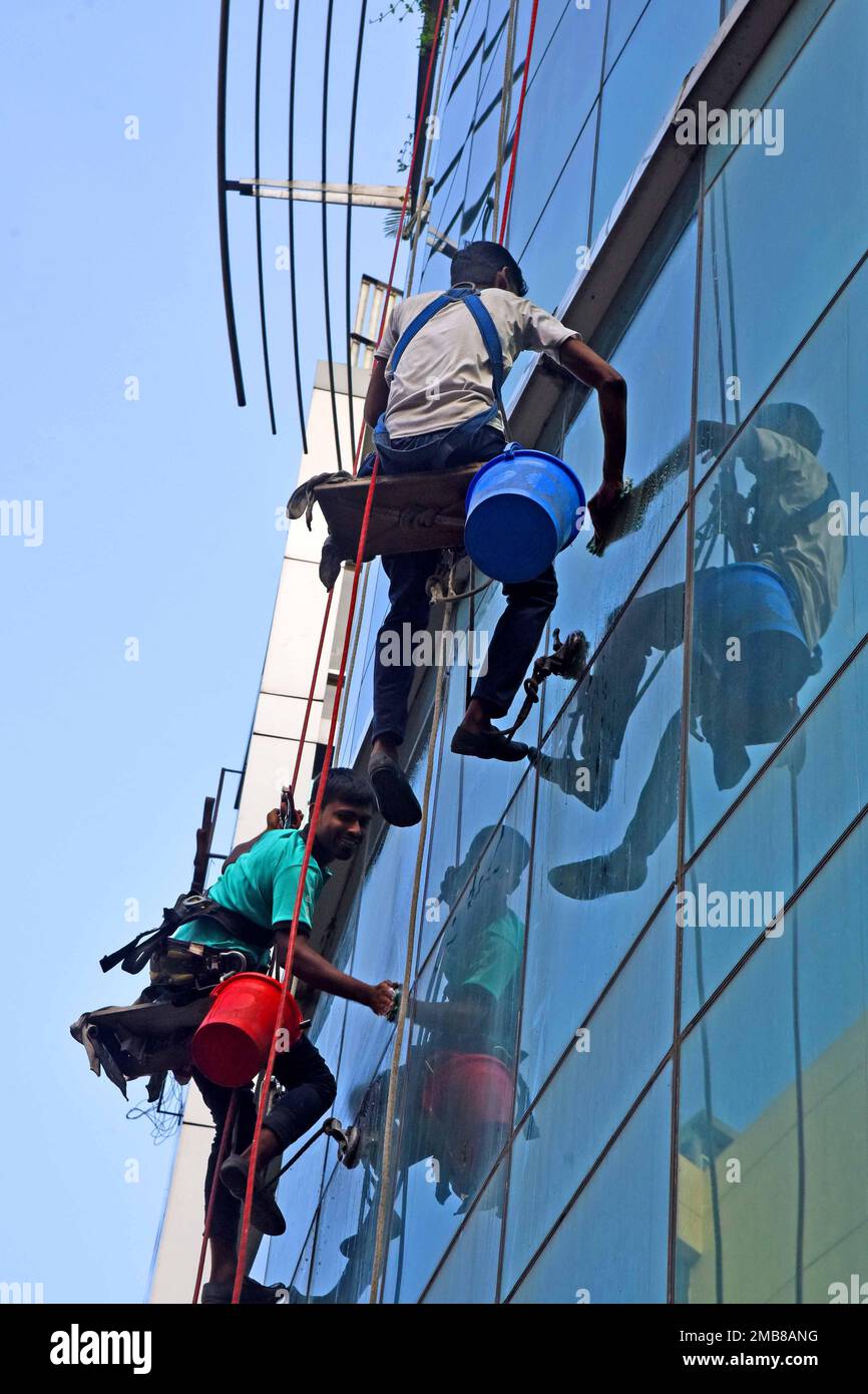 Workers glass cline a high-rise building on a construction site area in ...