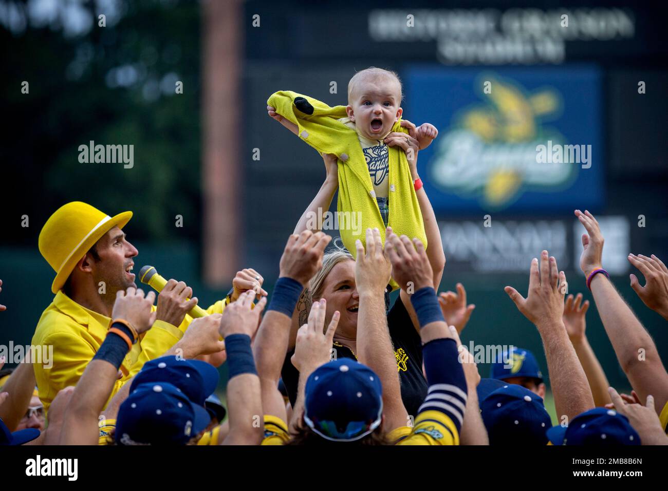 Molly Knutson holds her baby James Knutson high above the players as ...