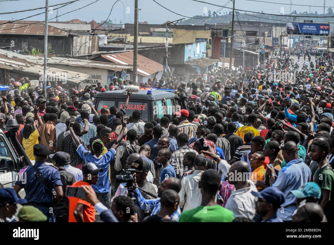 Residents fill the streets as they follow an ambulance containing the ...