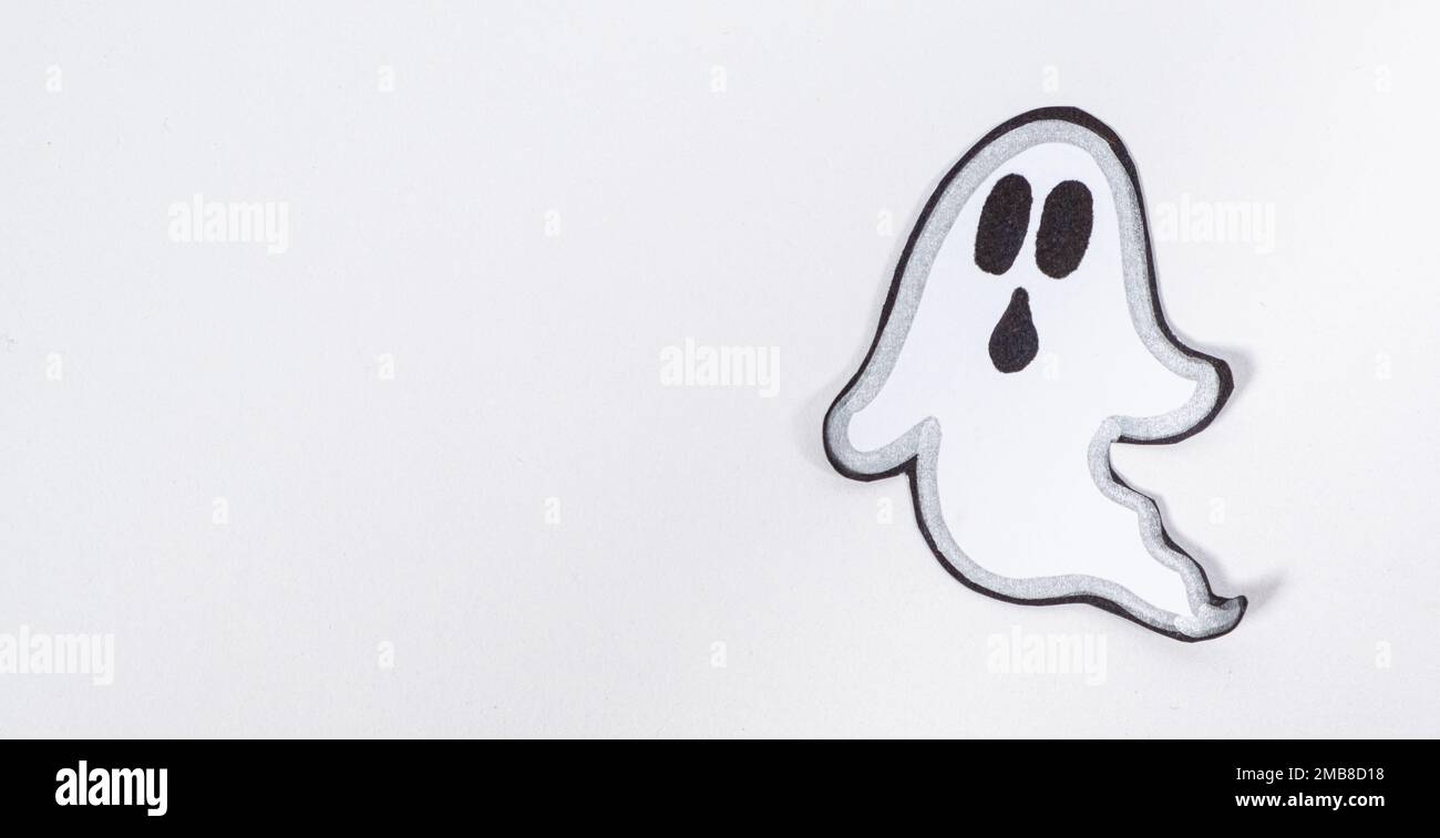 A scary but cute paper ghost with a face confuses on a white background ...