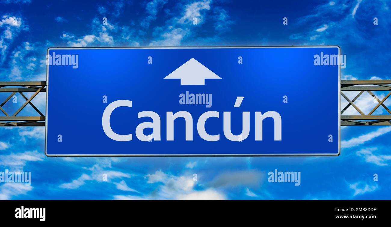 Road sign indicating direction to the city of Cancun Stock Photo - Alamy