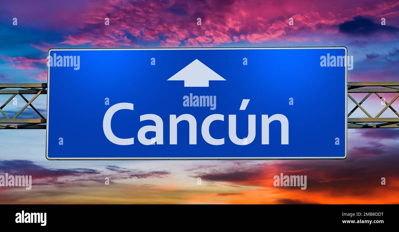 Road sign indicating direction to the city of Cancun Stock Photo - Alamy