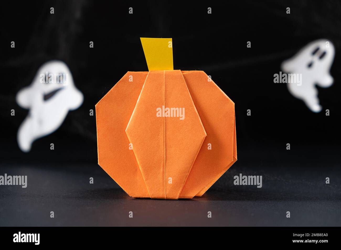 Origami pumpkin made of paper for the Halloween holiday, against the ...