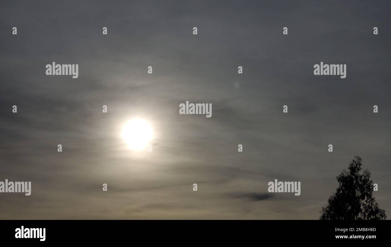 The sun seen through the cloudy sky Stock Photo - Alamy