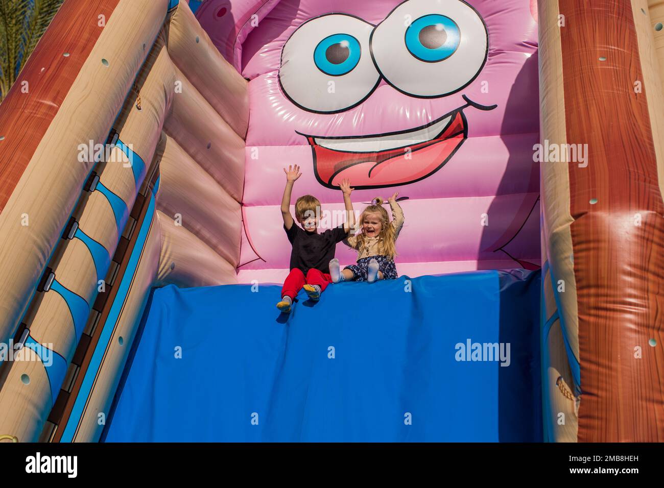 Kids having fun and sliding and jumping on outdoor playground. Kids ...