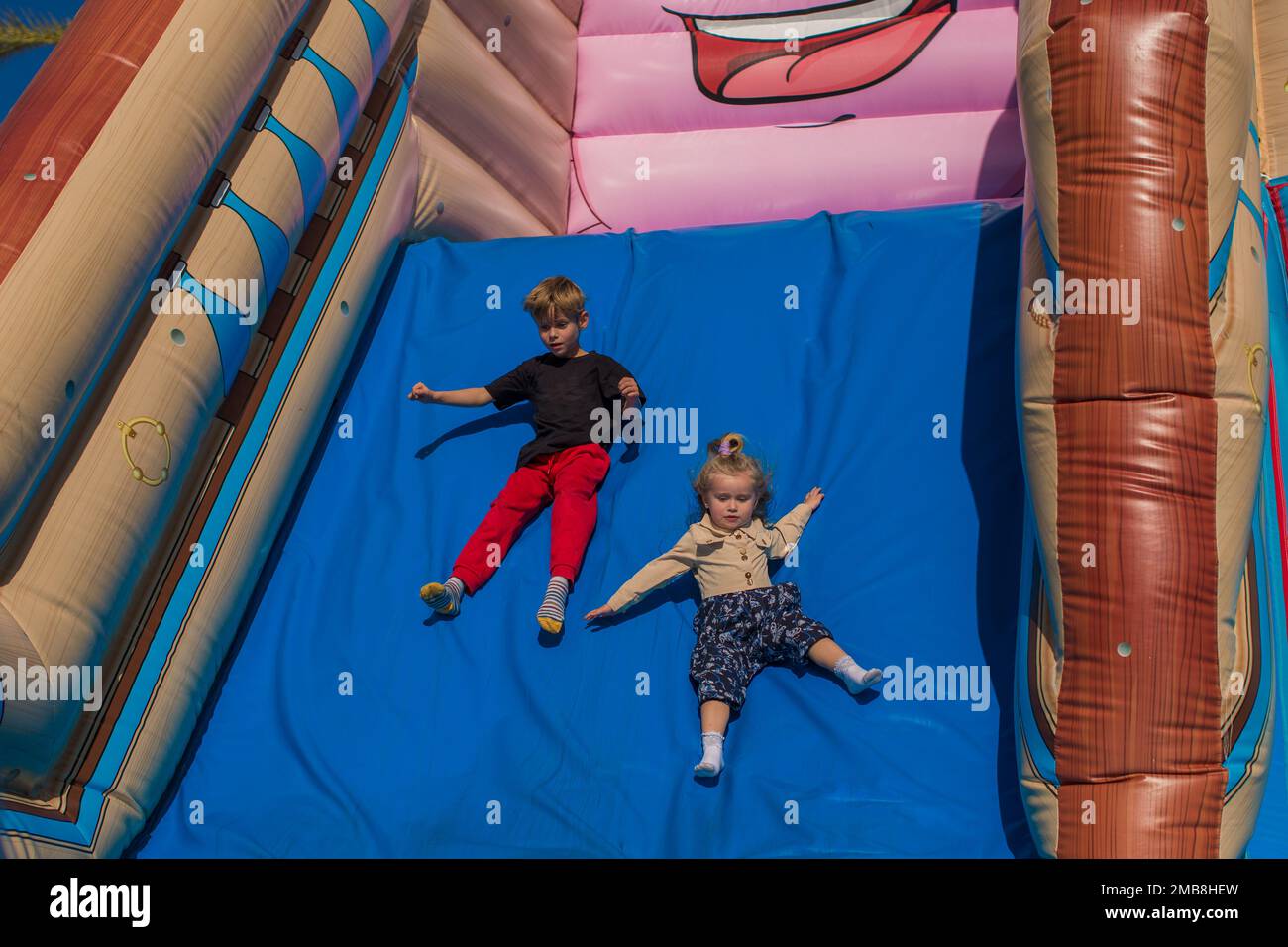 Kids having fun and sliding and jumping on outdoor playground. Kids ...