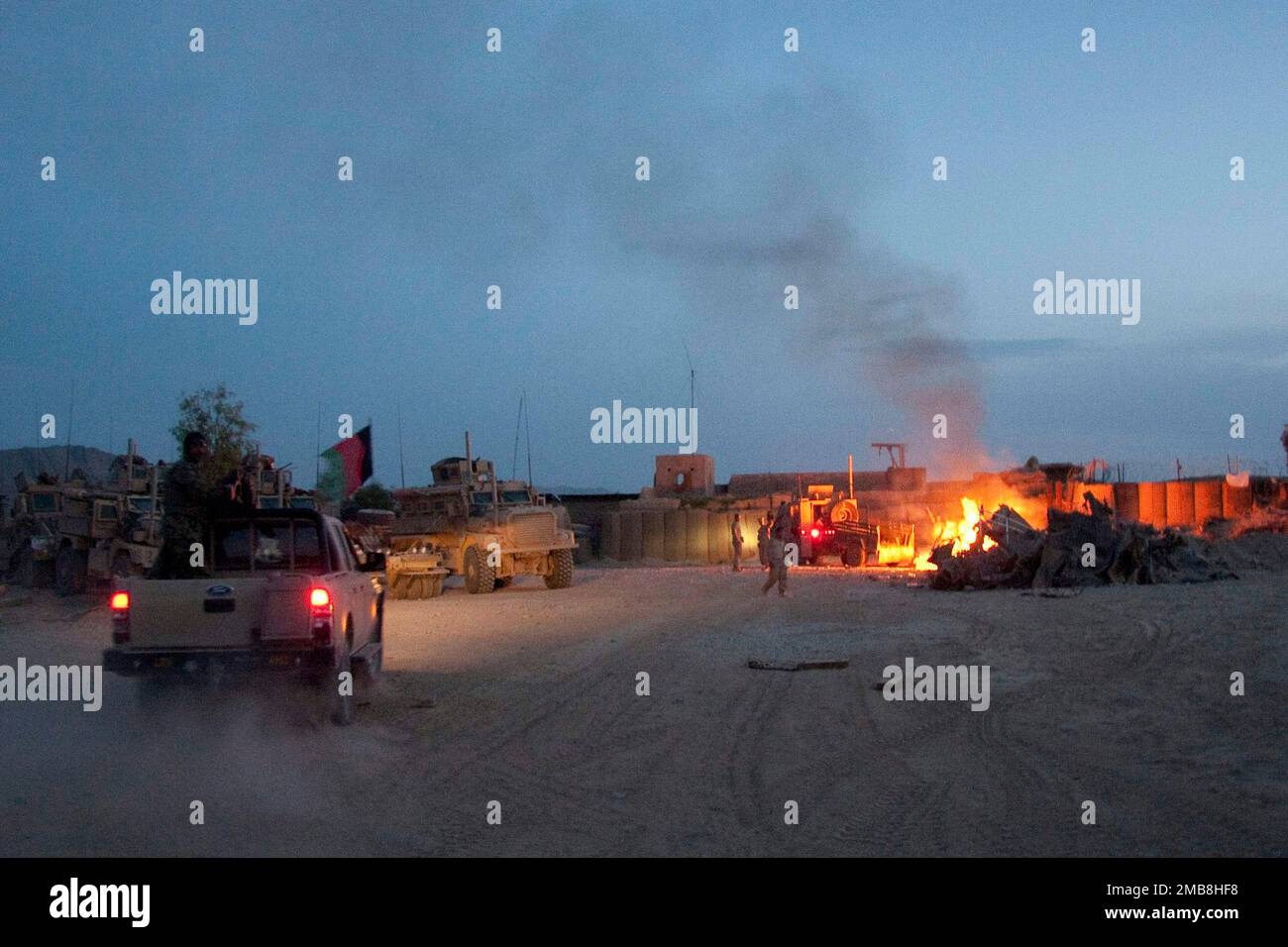 FILE - An Afghan National Army pickup truck passes parked U.S. armored ...