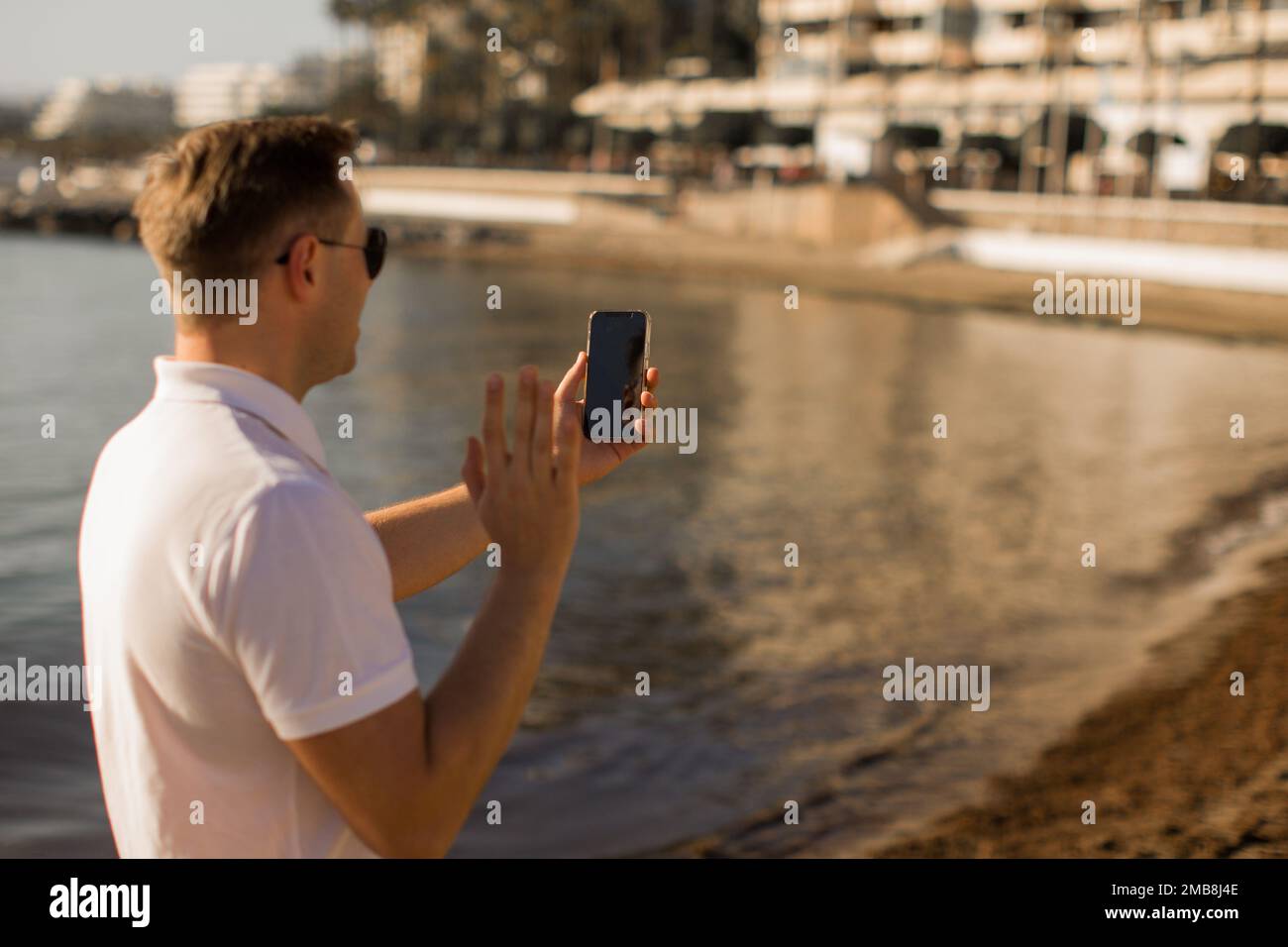 happy man on holiday relax walk along the beach use phone online live ...