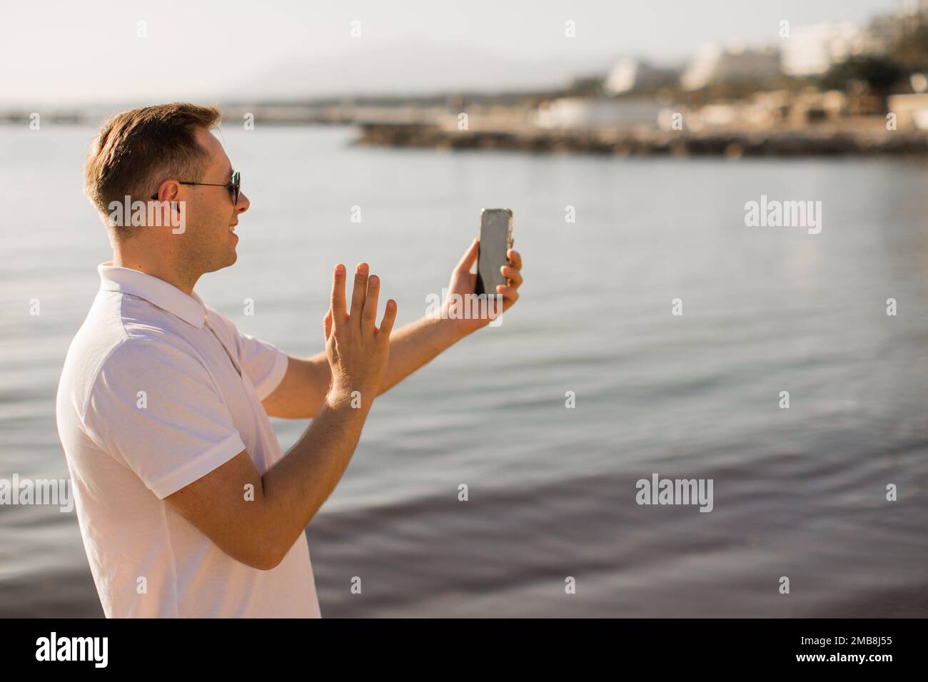 happy man on holiday relax walk along the beach use phone online live ...