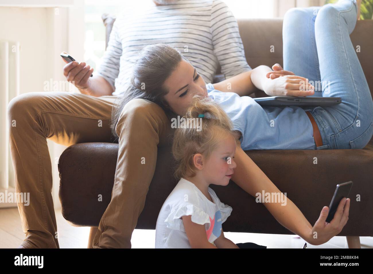 The little girl giggles as she watches cartoons on the smartphone with ...