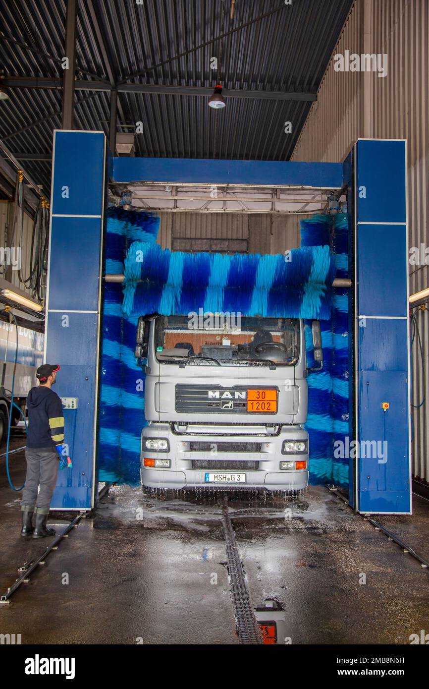 Netherlands truck driver cleans window while the truck is in a car wash ...