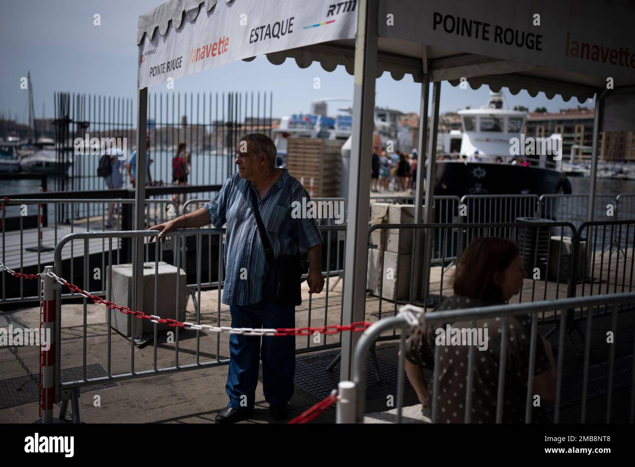 People wait in the shade for a ferry boat to arrive during a heat wave ...