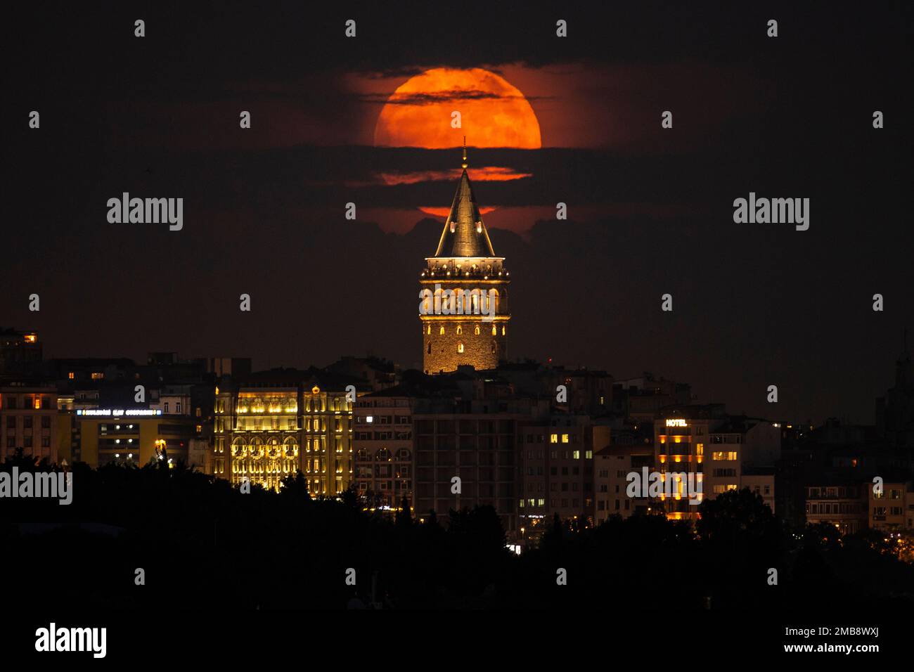 A supermoon rises behind the Galata Tower in Istanbul, Turkey, Tuesday ...