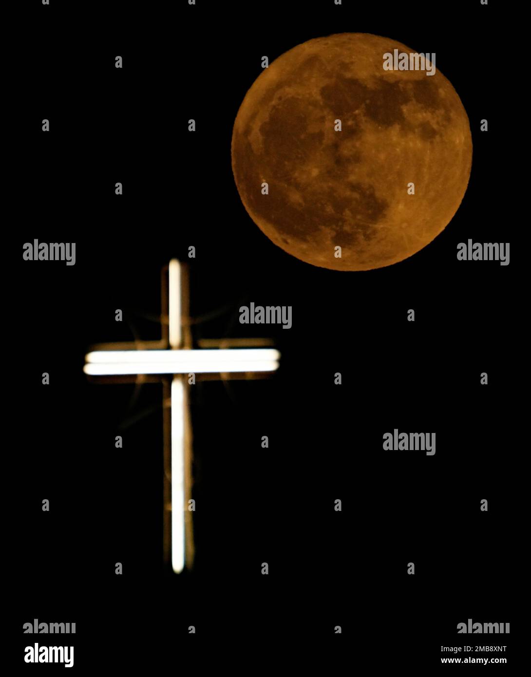 The full moon rises over the cross of St. Joseph Church in Baghdad ...