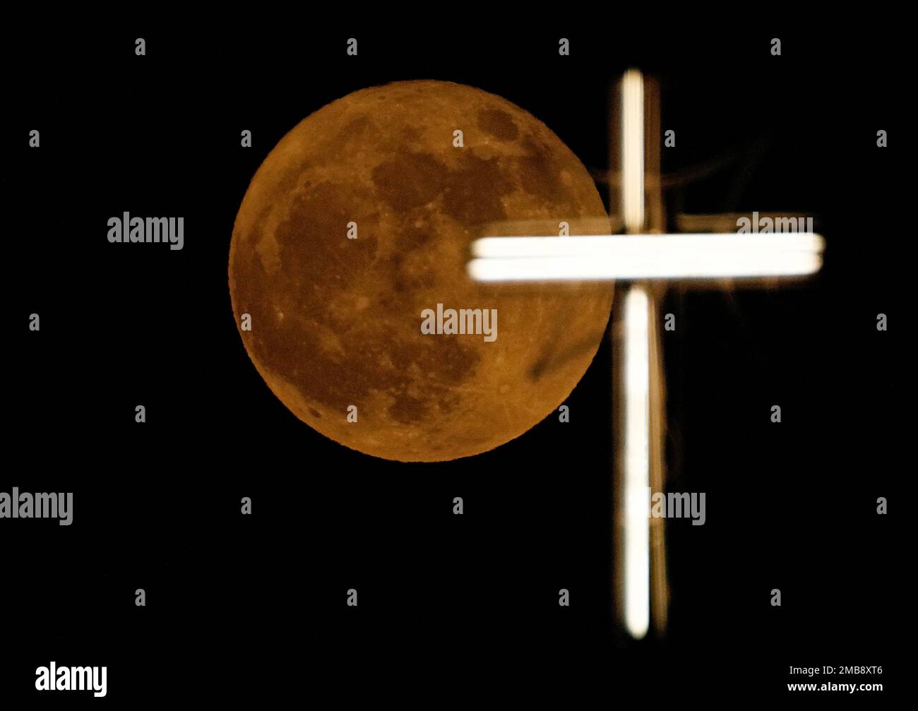 The full moon rises over the cross of St. Joseph Church in Baghdad ...