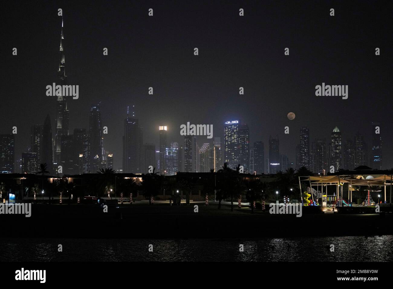 The full moon rises over the city skyline with world's tallest tower ...