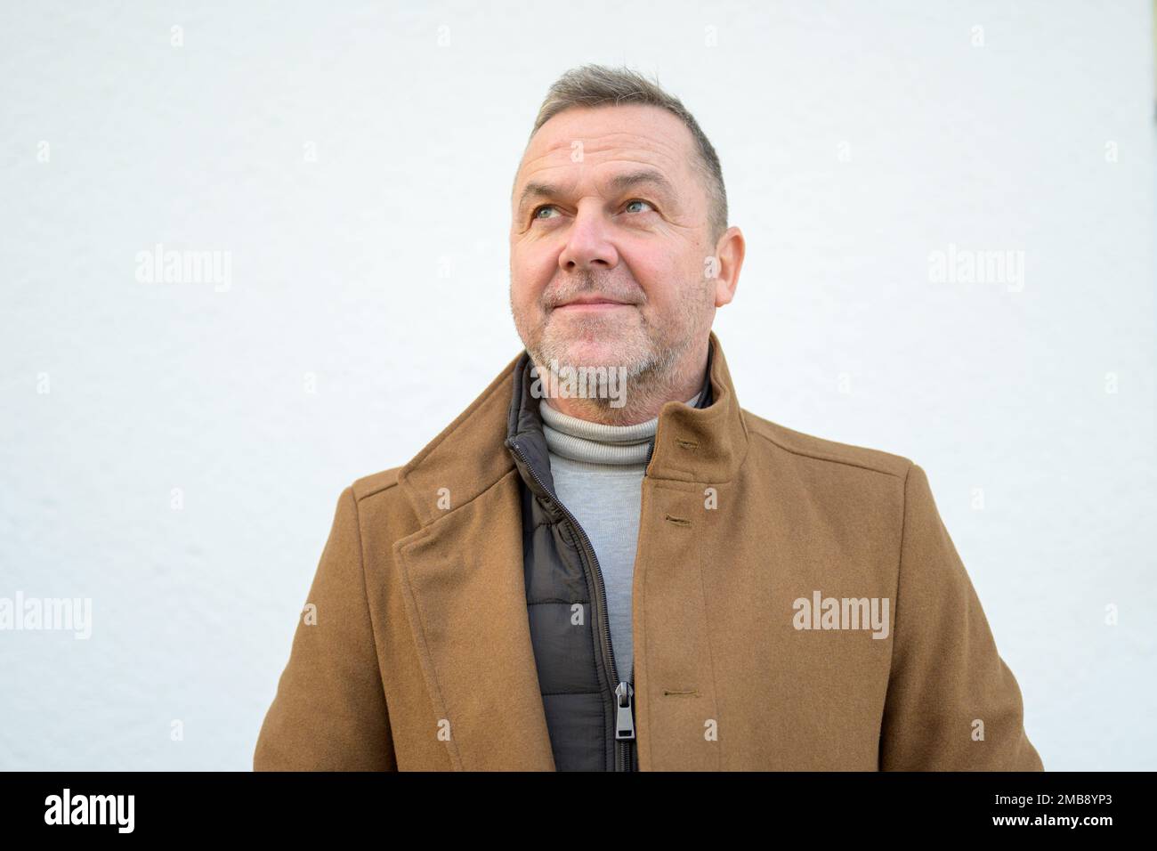 Portrait of a middle aged man with a gentle smile in a brown coat ...