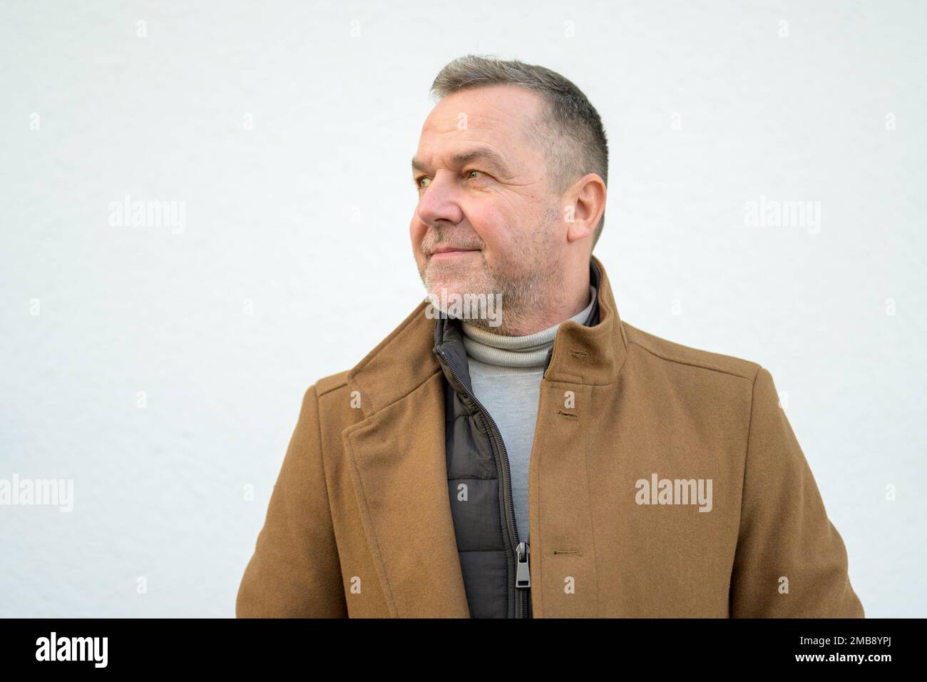 Portrait of a middle aged man with a gentle smile in a brown coat ...