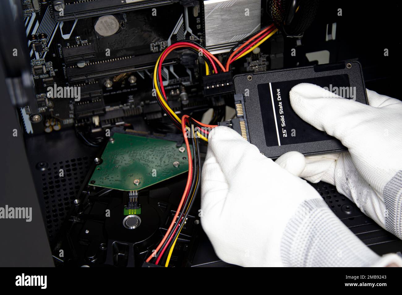 The mechanic is connecting the wires to the 2.5 inch SSD hard drive ...