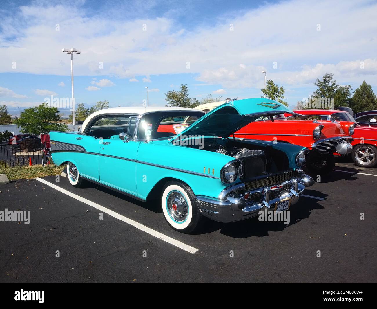 A blue Chevrolet Bel Air with an open bonnet on the asphalt, clear sky ...