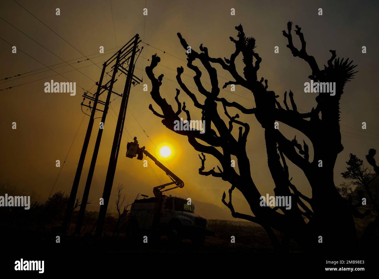 A SoCal Edison worker fixes the power lines that were damaged from the ...