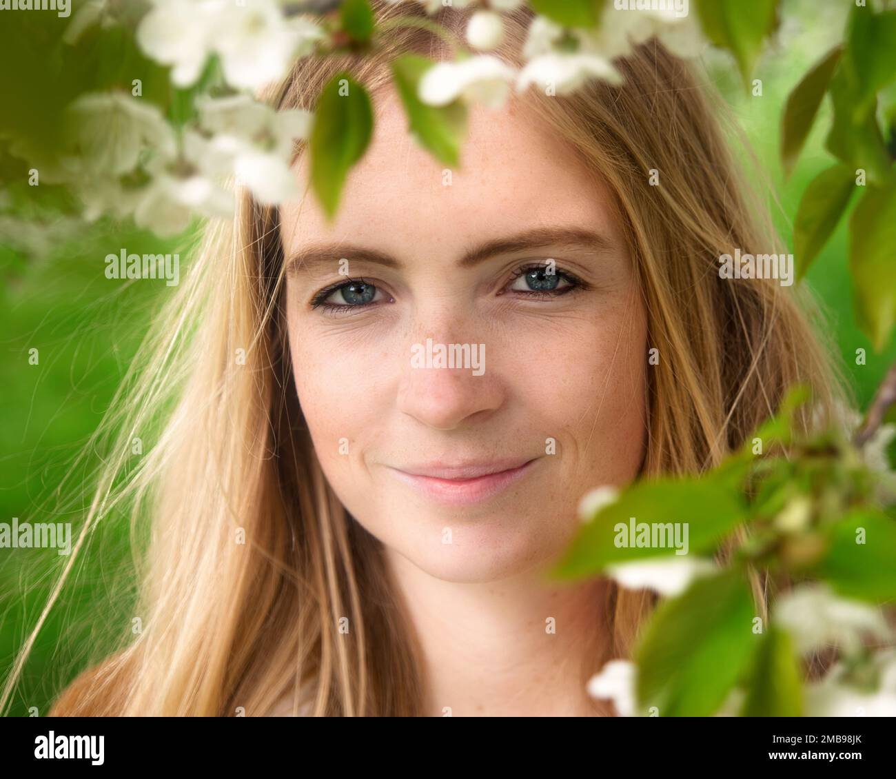 Portrait of a beautiful young smiling woman in nature, with spring ...