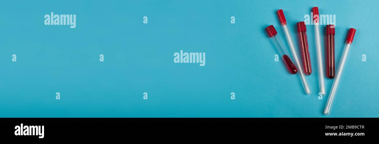 Top view of blood samples near throat swabs on blue background, banner ...