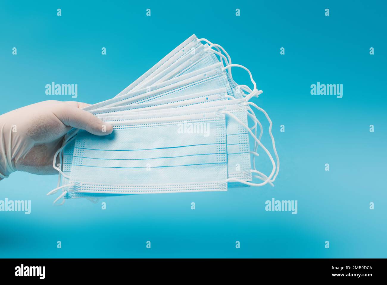 Cropped view of doctor in latex gloves holding medical masks isolated ...
