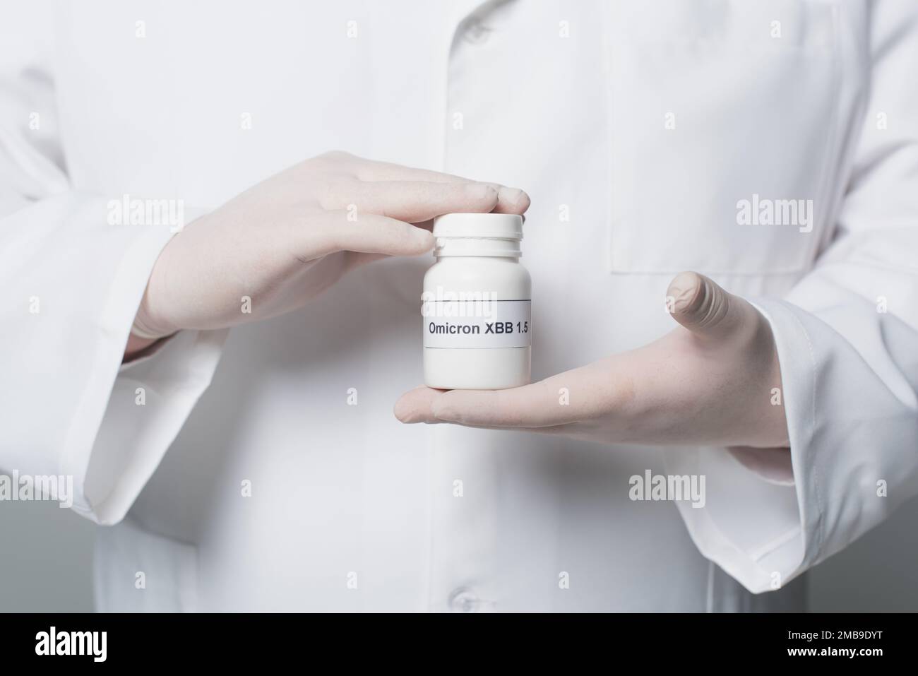 Cropped view of doctor in white coat and gloves holding jar with ...
