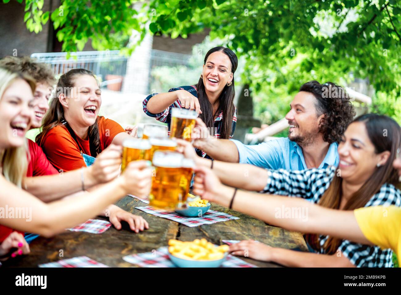 Young friends drinking and toasting beer at brewery bar restaurant ...