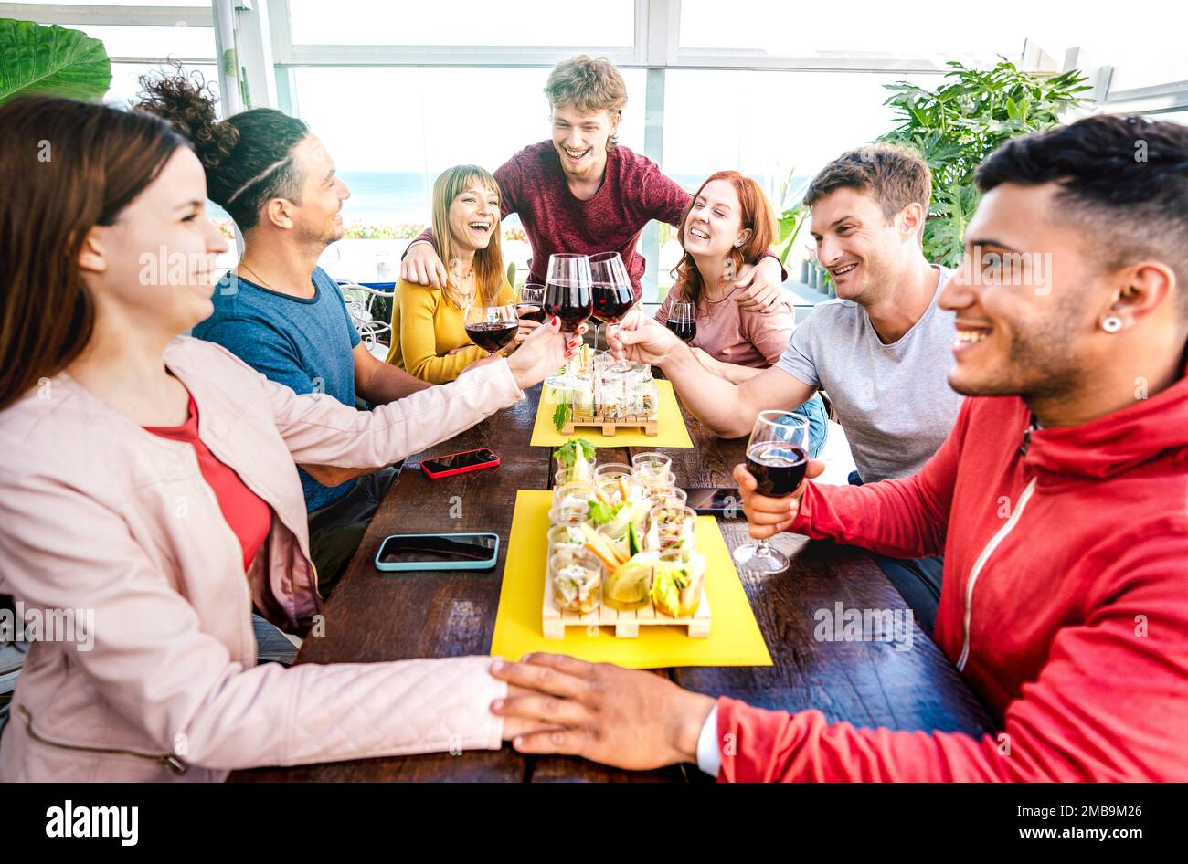 Happy young people having fun together drinking wine at penthouse on ...