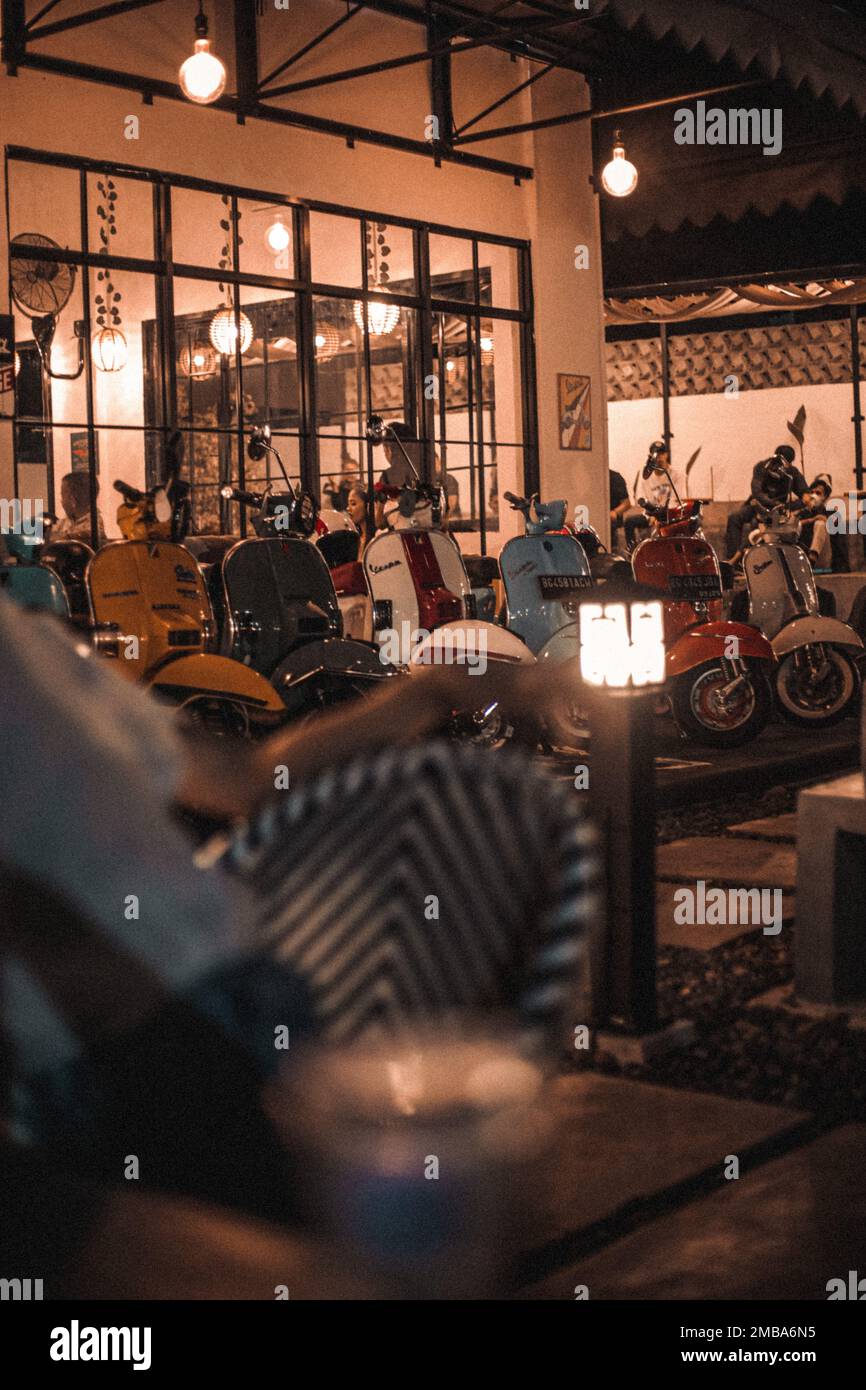 A vertical of people enjoying their evening in an open cafe Stock Photo ...