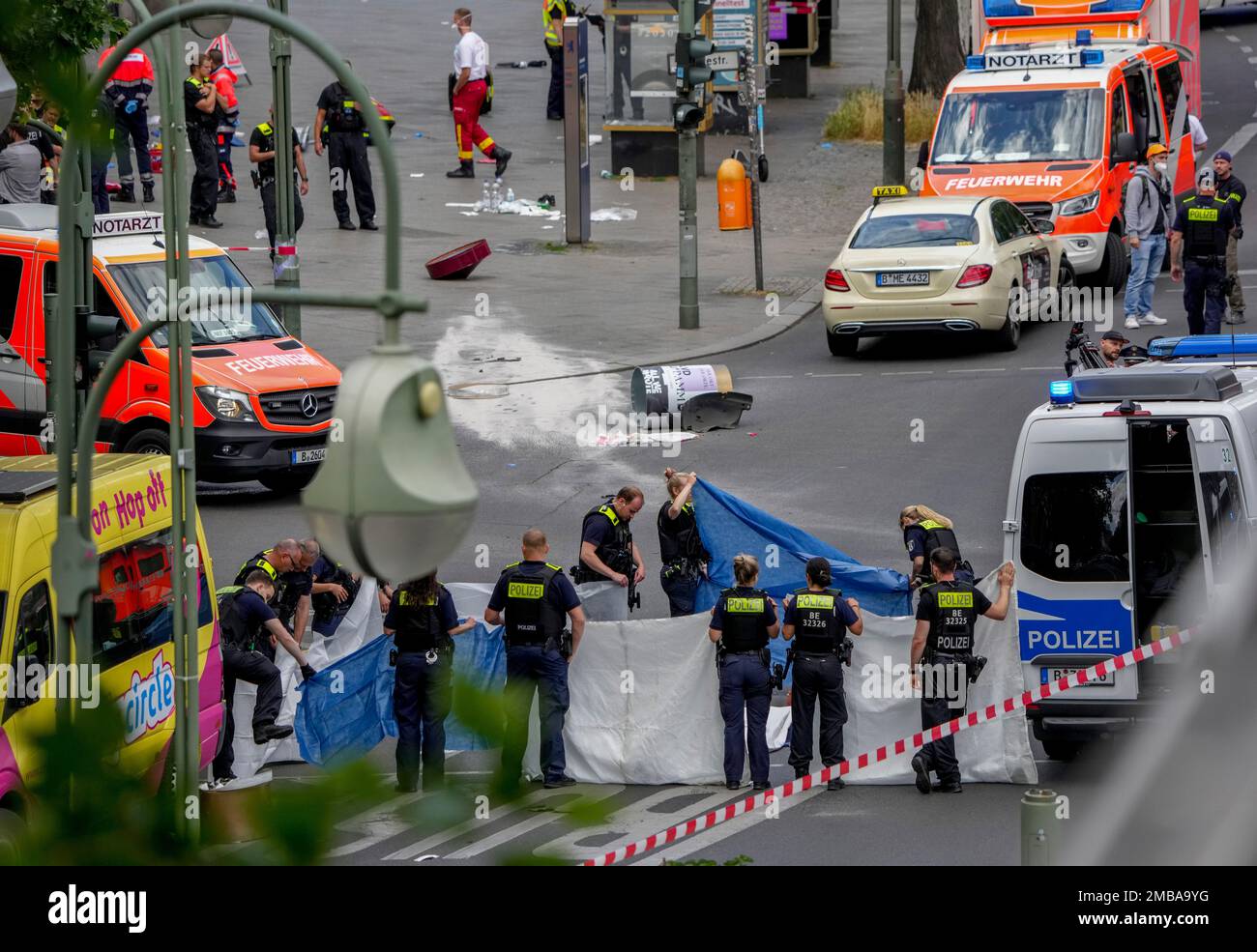 Police officers cover a dead body after a car crashed into a crowd of ...