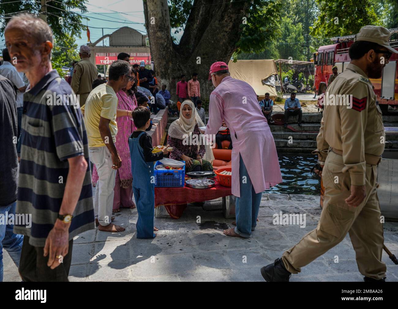 A Kashmiri Muslim woman, center, sells worship materials to Hindu ...