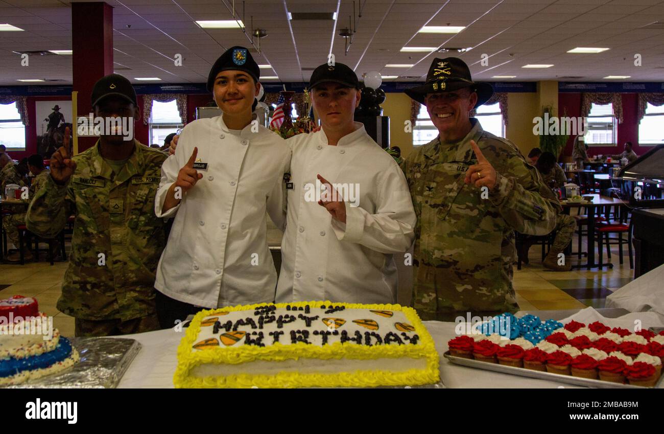 Col. Kevin S. Capra poses with culinary specialists in front of cakes ...