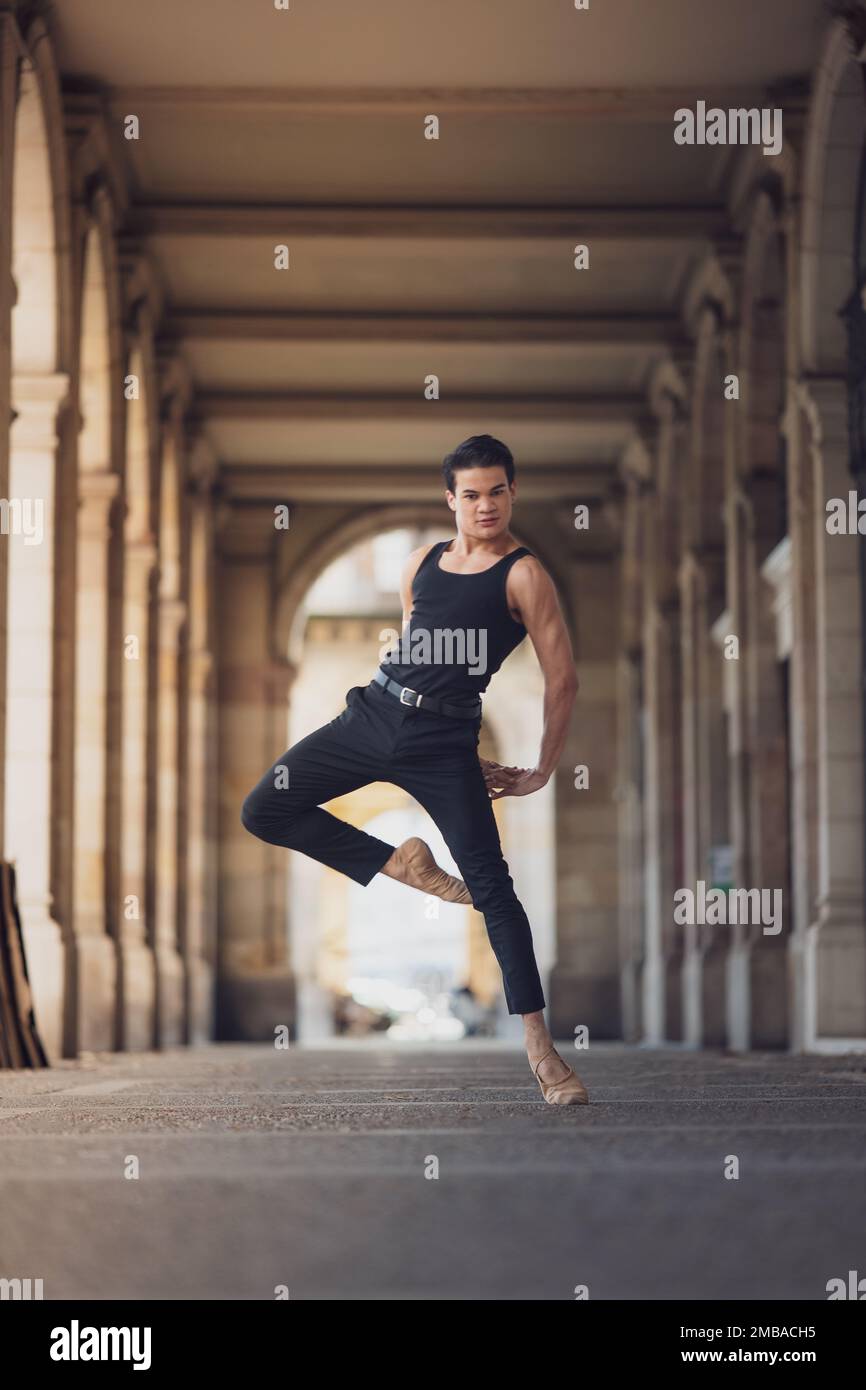 Young man dancing classic ballet in the streets of Barcelona with a ...