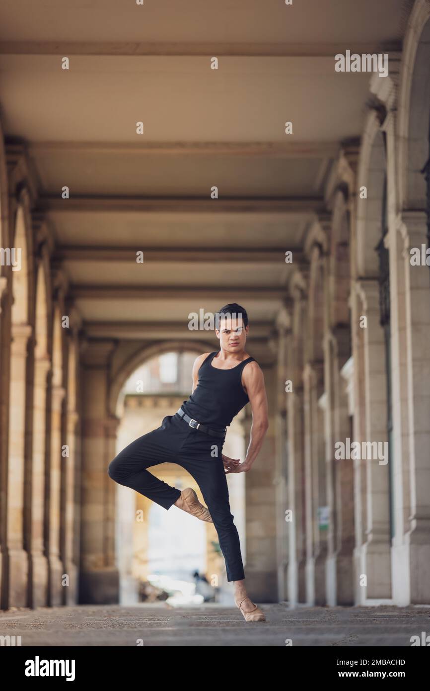 Young man dancing classic ballet in the streets of Barcelona with a ...