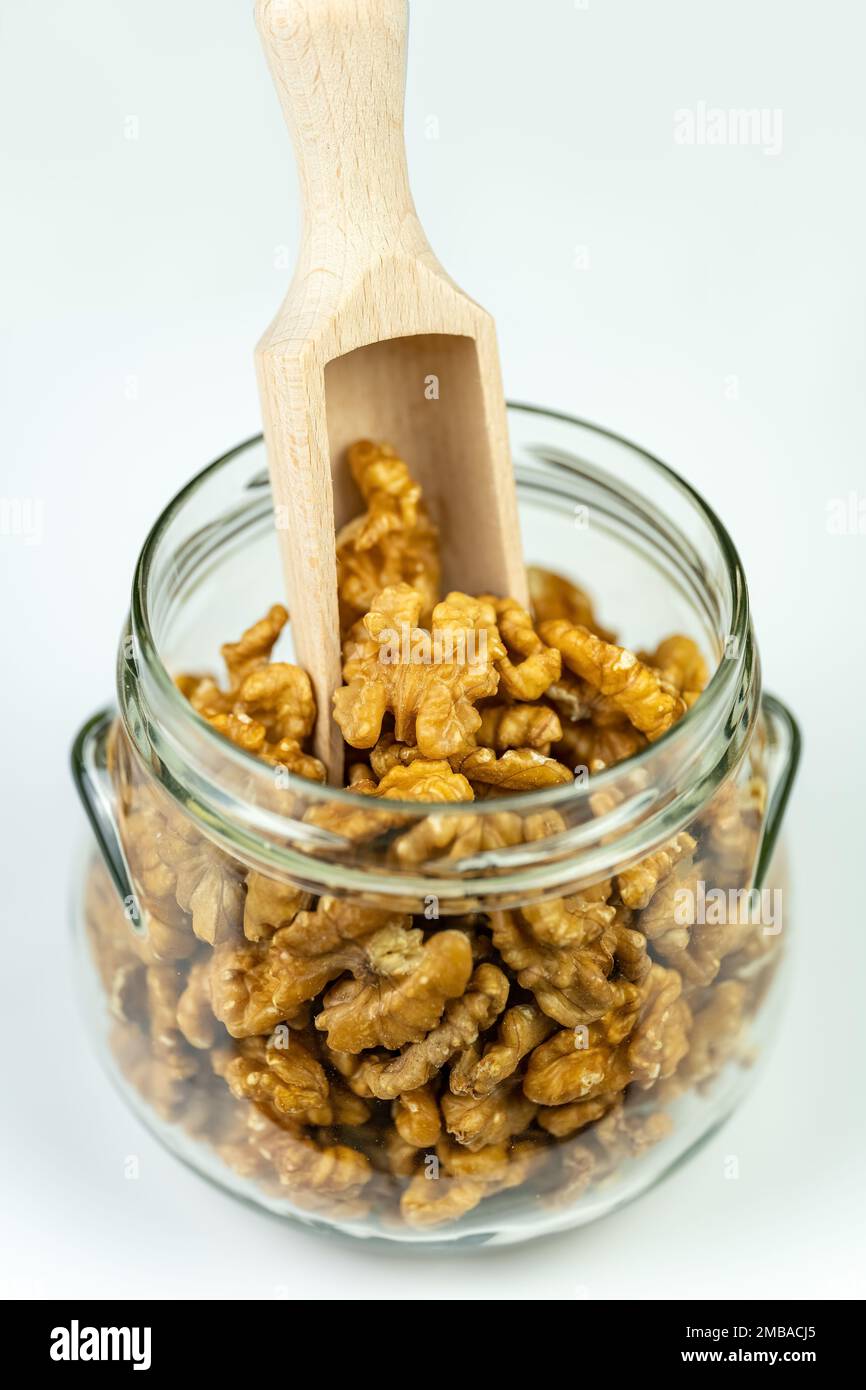 Glass jar full of peeled walnuts with wooden stick to catch them ...