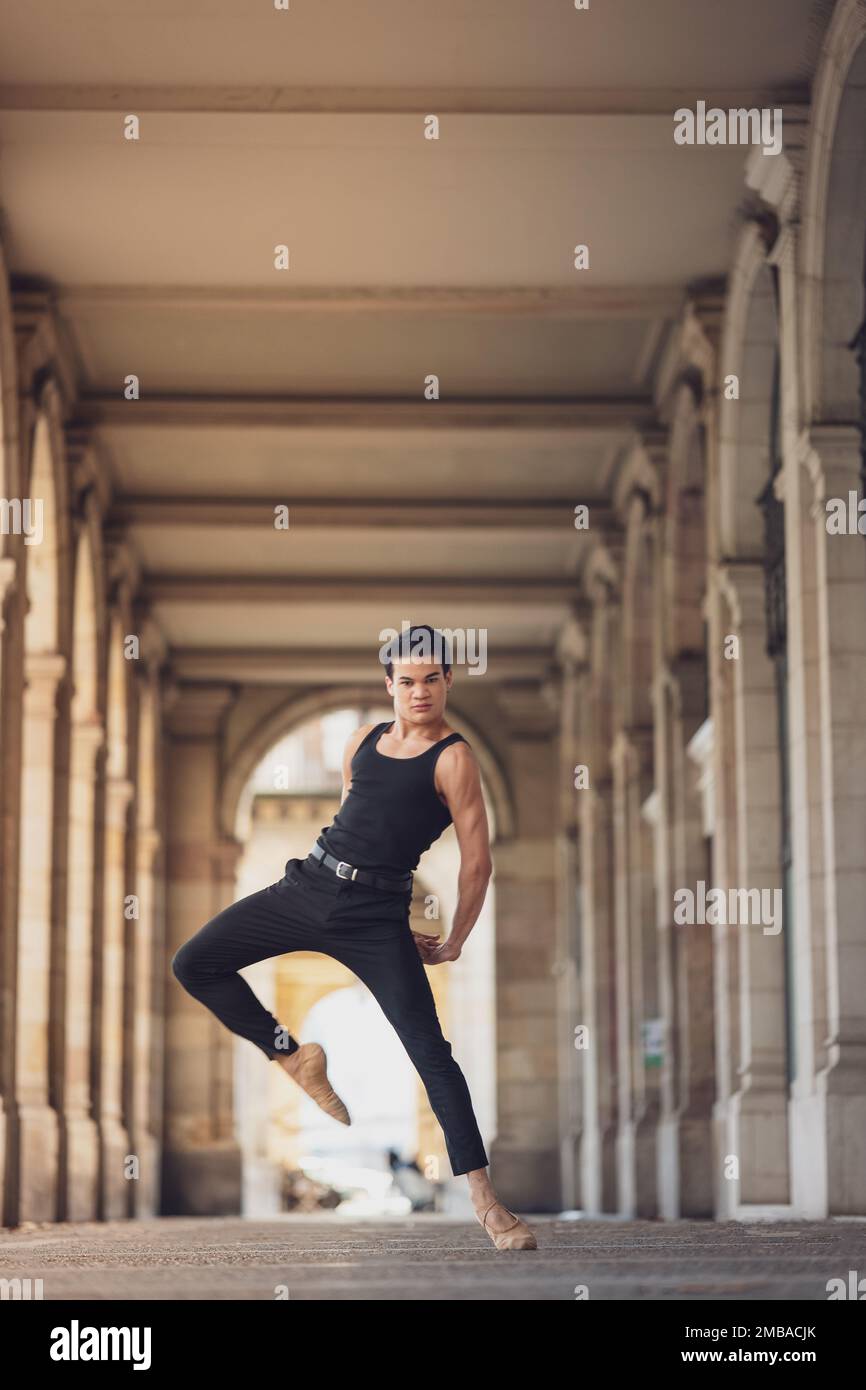 Young man dancing classic ballet in the streets of Barcelona with a ...