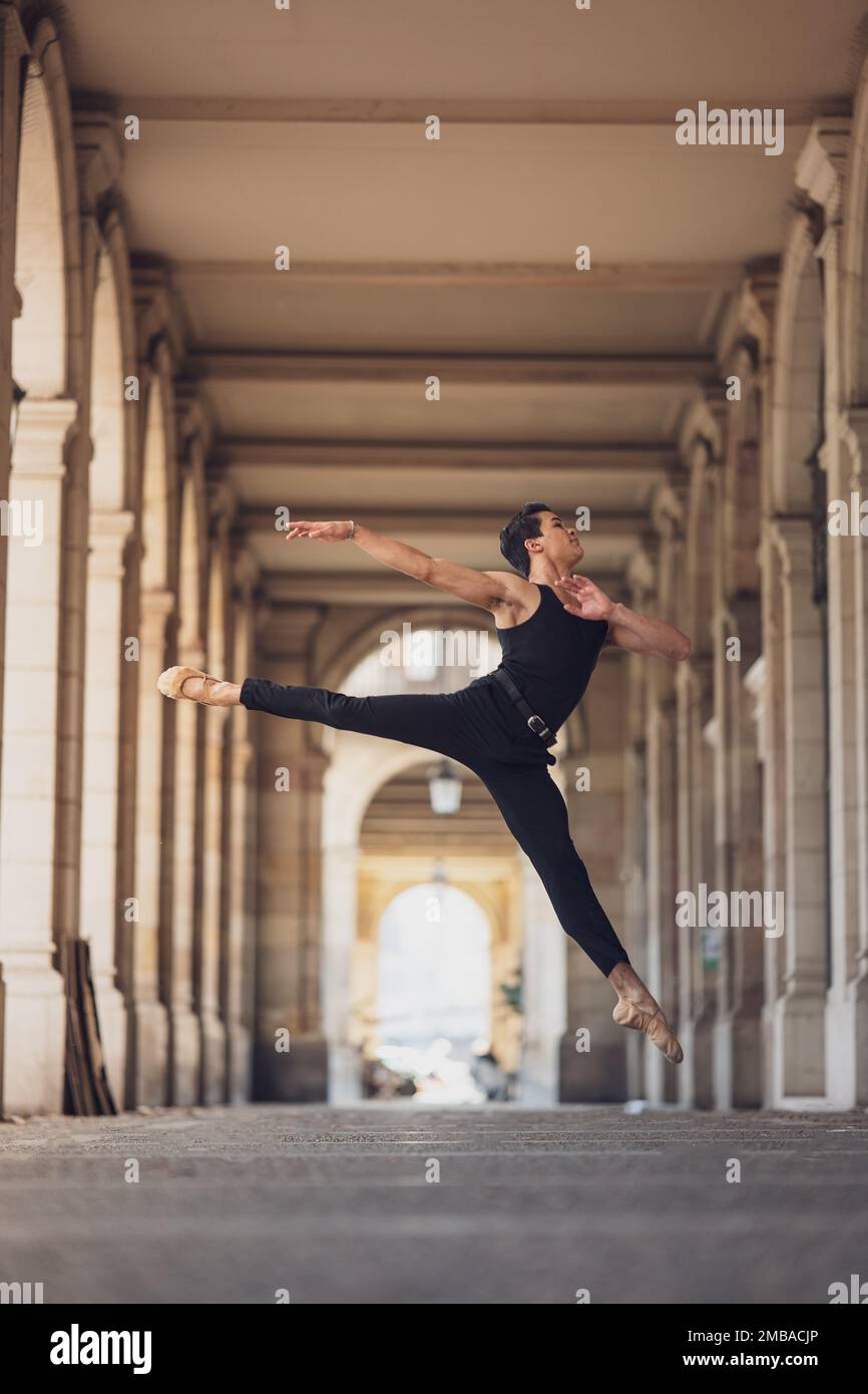 Young man dancing classic ballet in the streets of Barcelona with a ...